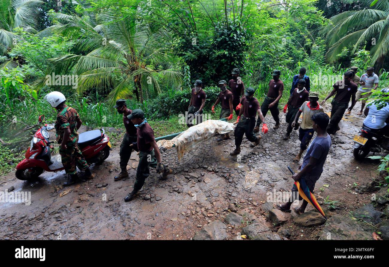 Sri Lankan army soldiers carry the body of a victim of a mudslide in Kiribathgala village in ...