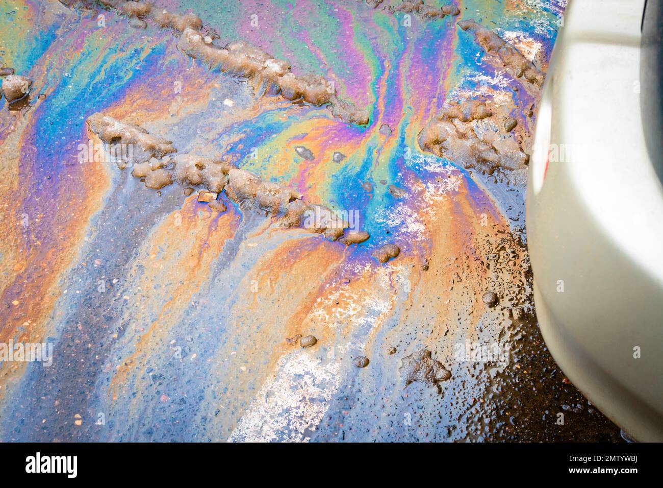 Taches de gaz colorées sur l'asphalte humide. Taches d'huile ou d ...