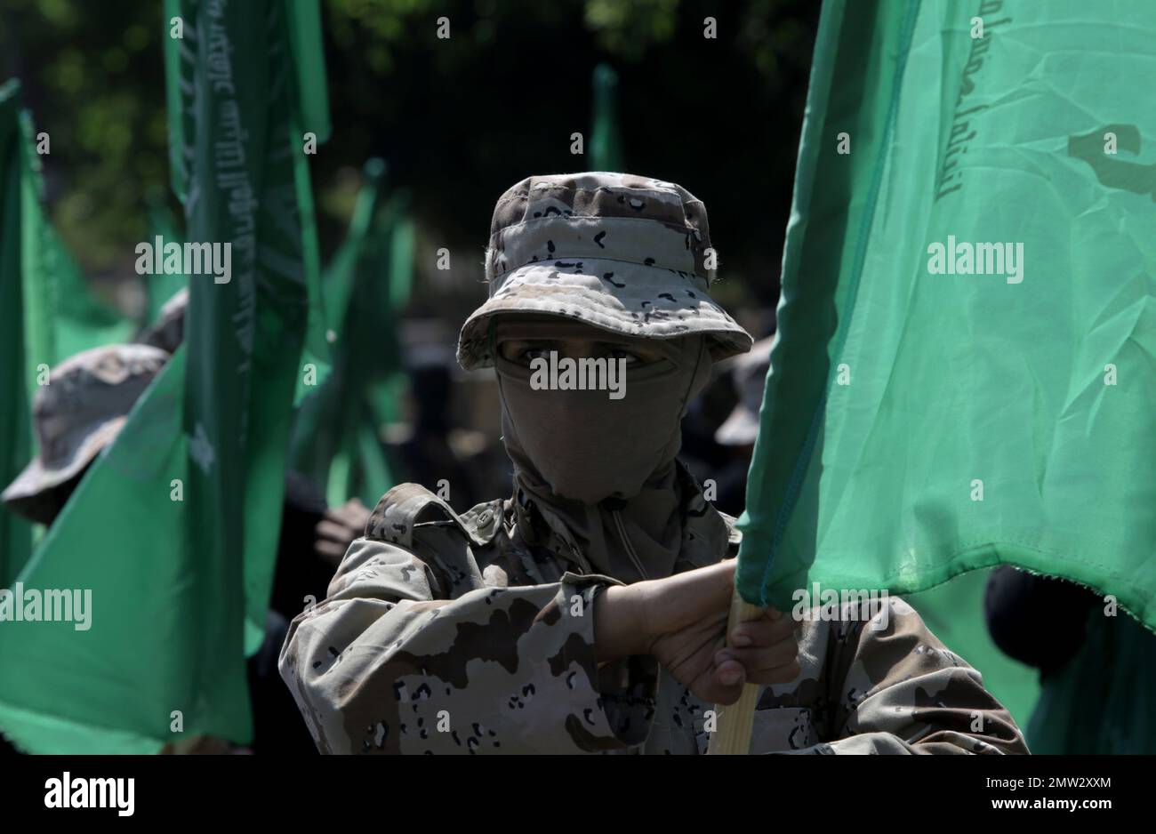 A masked militant from the Izzedine al-Qassam Brigades, a military wing ...