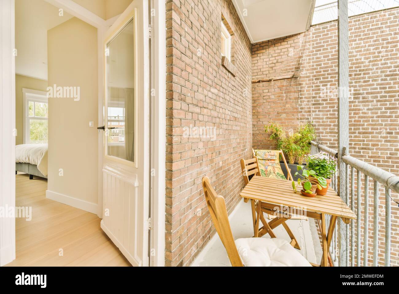 un petit balcon avec des murs en briques et une table en bois sur le ...