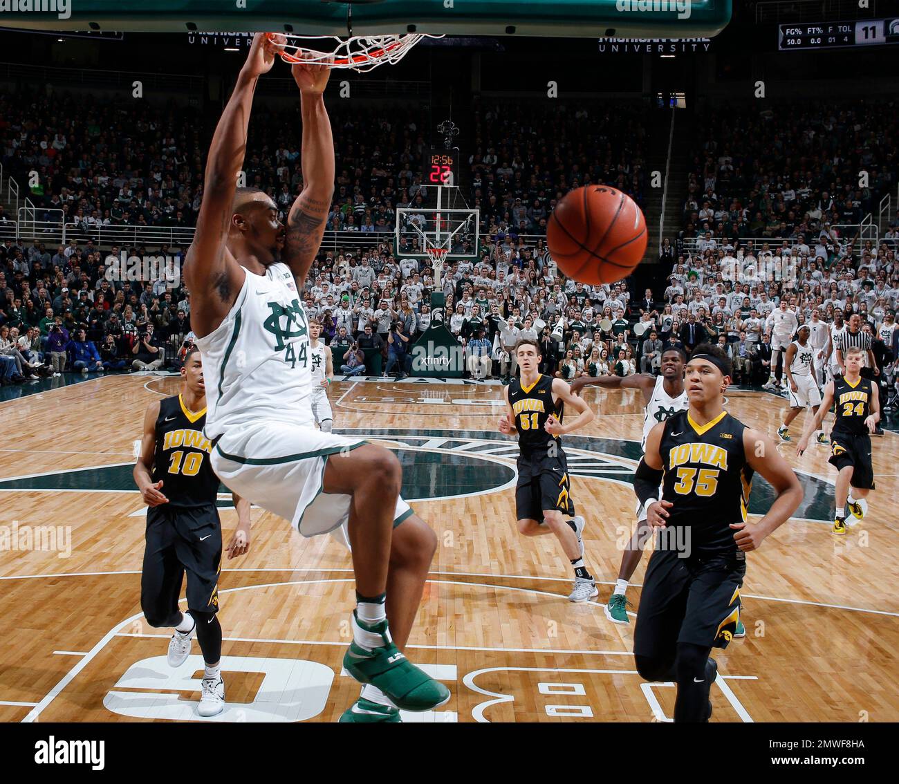 Michigan State's Nick Ward, left, dunks against Iowa's Cordell Pemsl ...