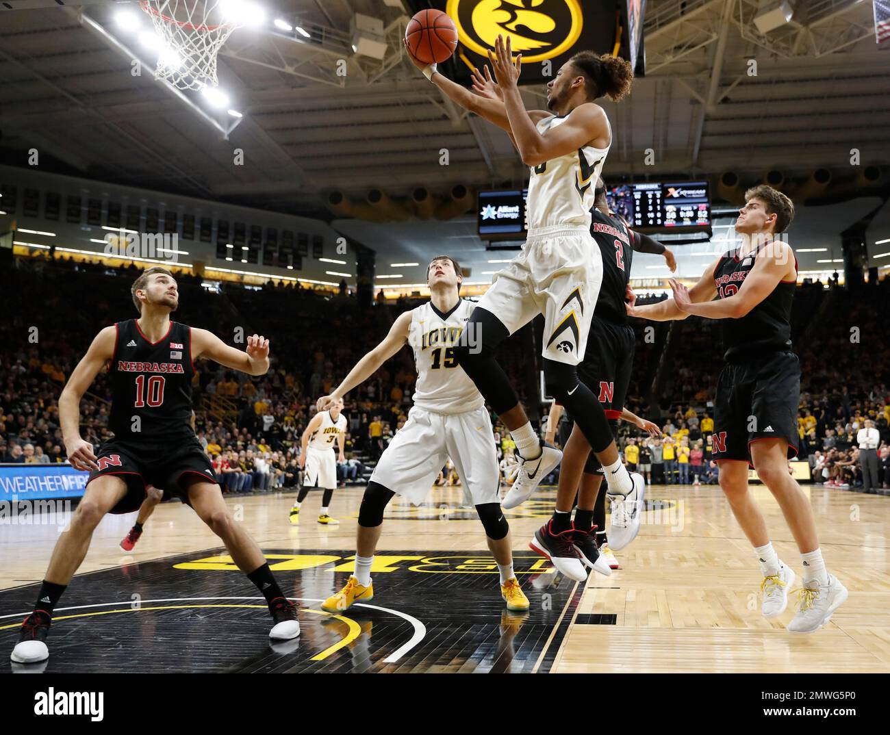 Iowa forward Dom Uhl, center, drives to the basket over Nebraska's Jack ...