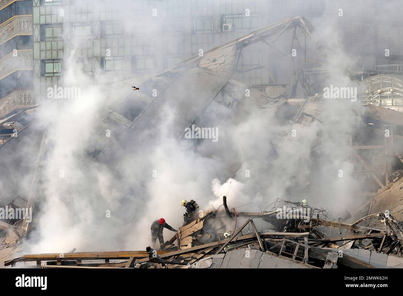 Firefighters work at the scene of the collapsed Plasco building after ...