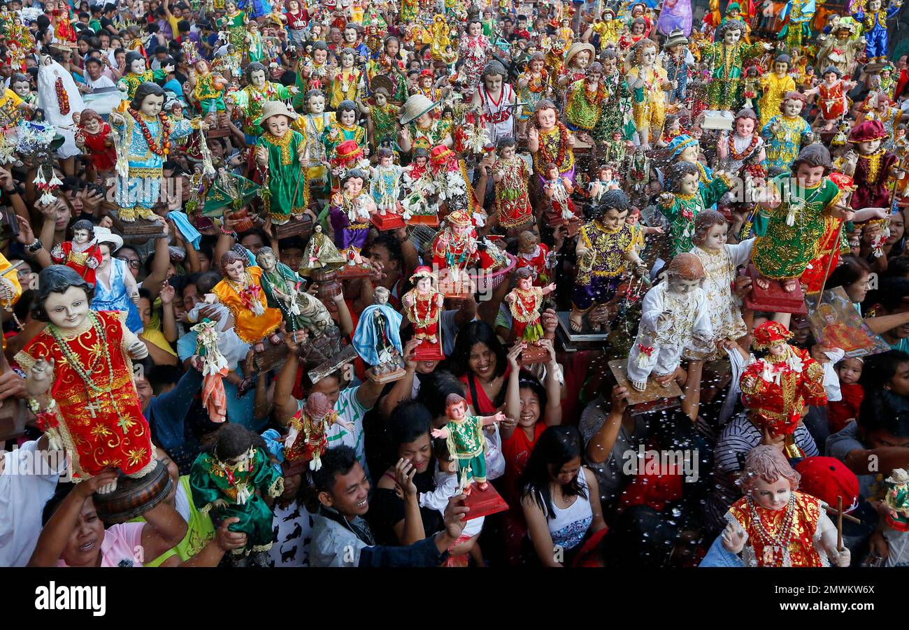 Roman Catholic devotees raise their images of the Child Jesus to be ...