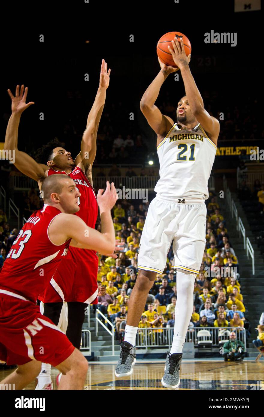 Michigan guard Zak Irvin (21) takes a jump shot, defended by Nebraska ...
