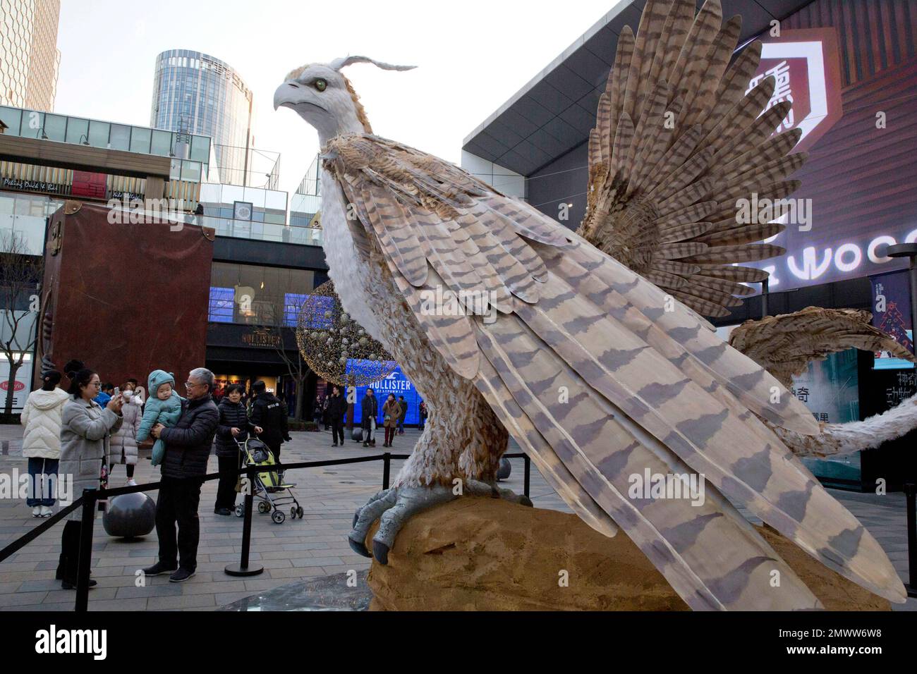 Shoppers at a mall look over a life size replica of a creature from the ...