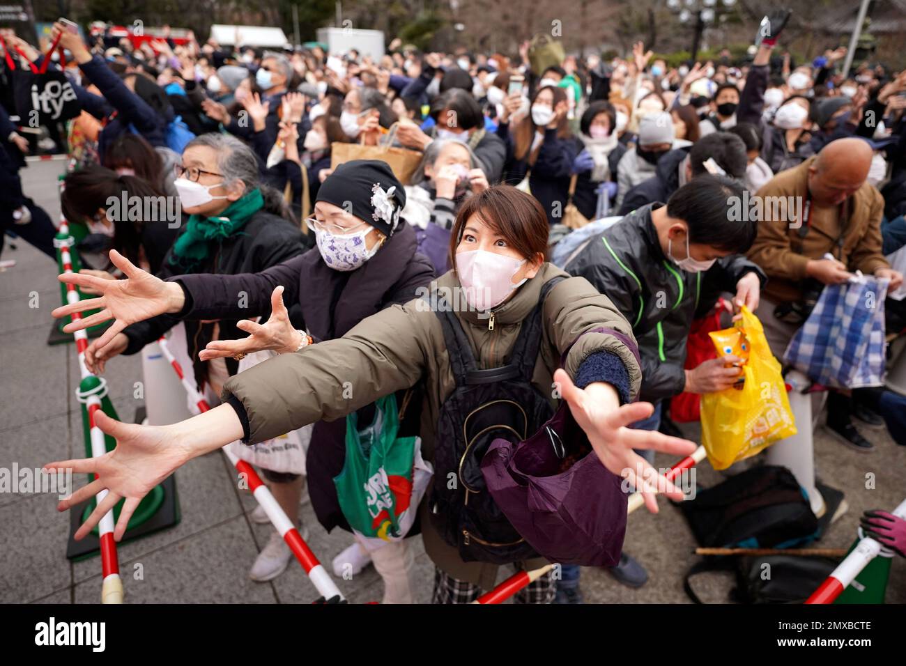 People try to catch lucky beans scattered by celebrities during the ...