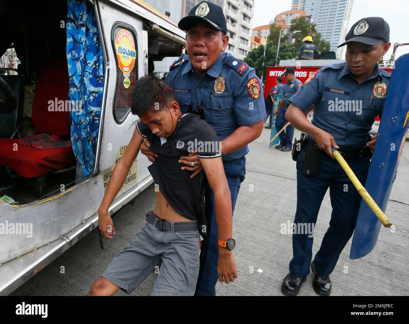 A police officer helps a bloodied protester after he was injured in a ...