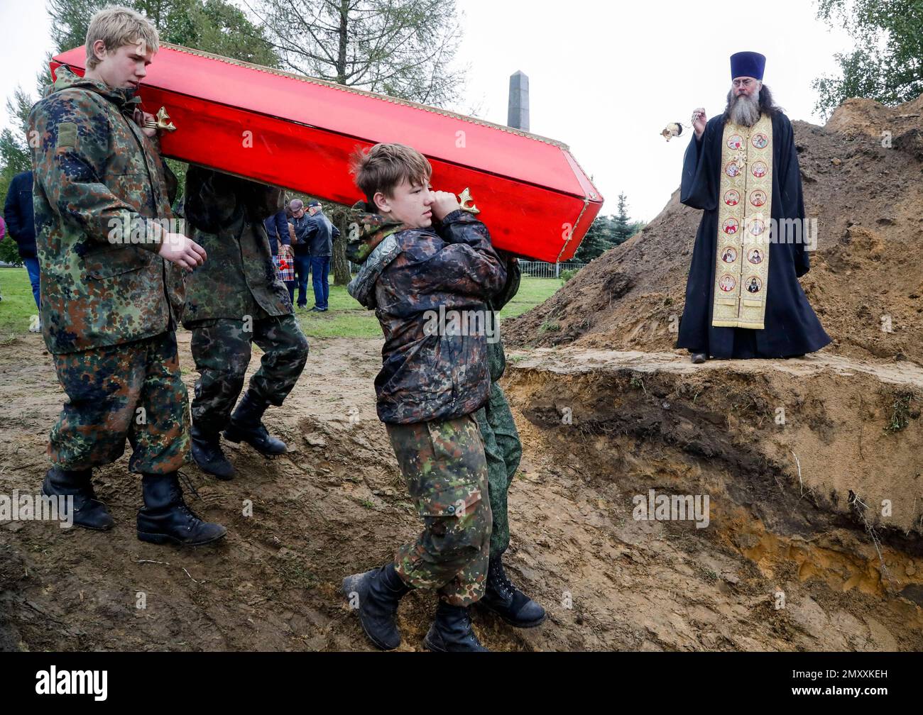 Members of volunteer search teams carry coffins containing remains of ...