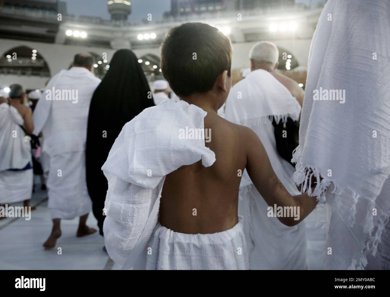 A child holds on to his father as he circles the Kaaba, Islam's holiest ...