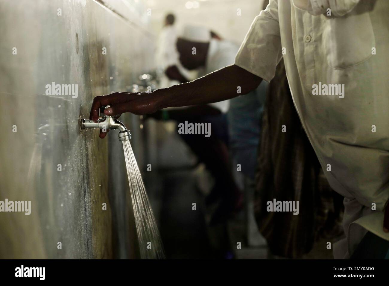 Muslim pilgrim performs Wudu, a ritual washing before prayers, just ...