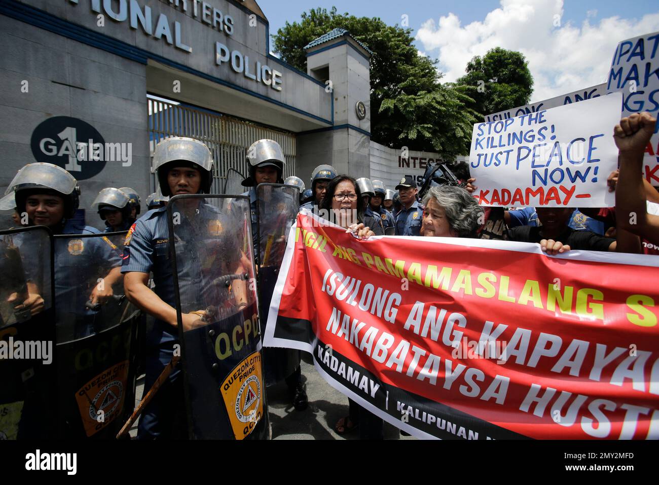 Filipino activists hold placards and shout slogans calling for an end ...