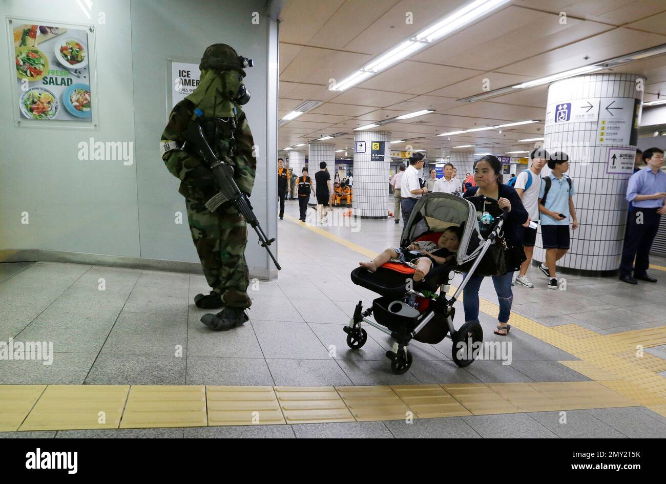 A woman pushes a baby as a South Korean army soldier watches during an ...
