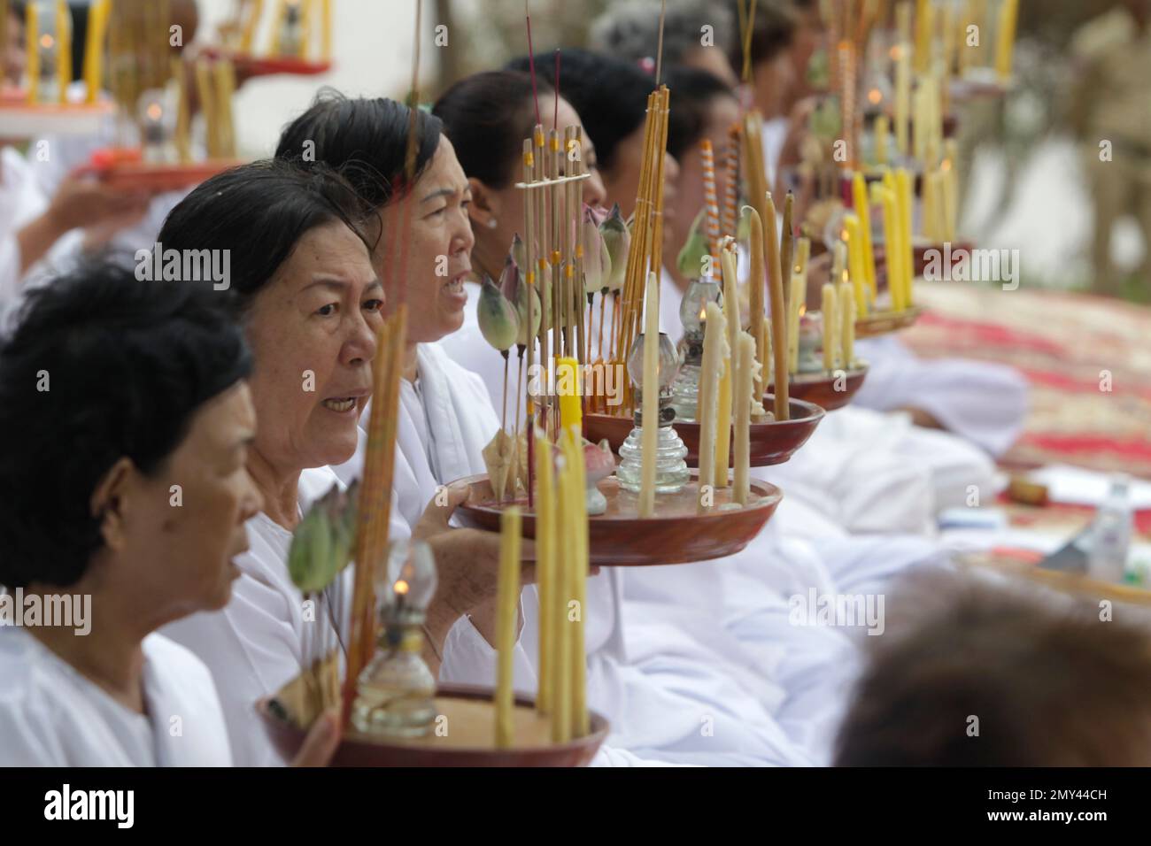 Cambodian Buddhist followers hold plastic trays loaded with candles and ...
