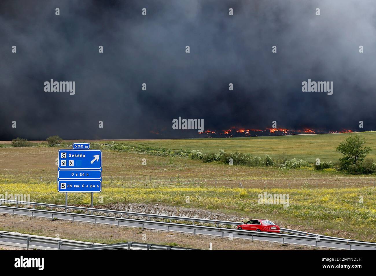 A car drives past burning tyres in Sesena, central Spain, Friday, May ...