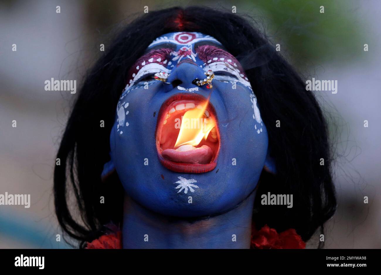 An Indian man dressed as Hindu Goddess Kali puts fire in his mouth ...
