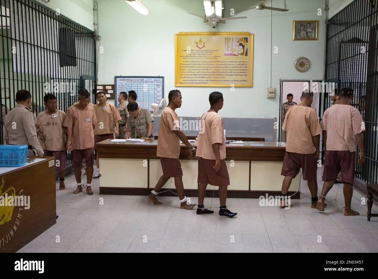 Prisoners are escorted by Thai correction officers from a holding cell ...