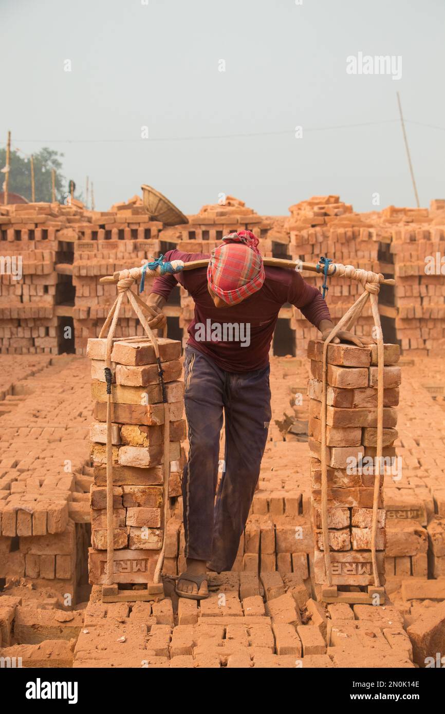 Les gens travaillent dur dans le domaine de la brique. Cette image a ...