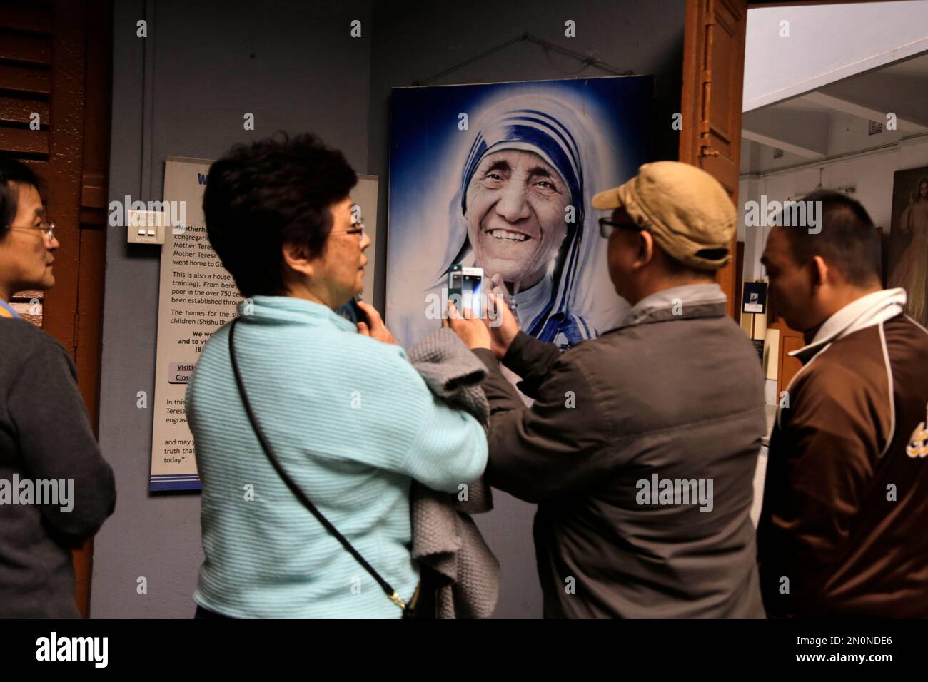 Visitors take photos of a portrait of Mother Teresa at the Missionaries ...