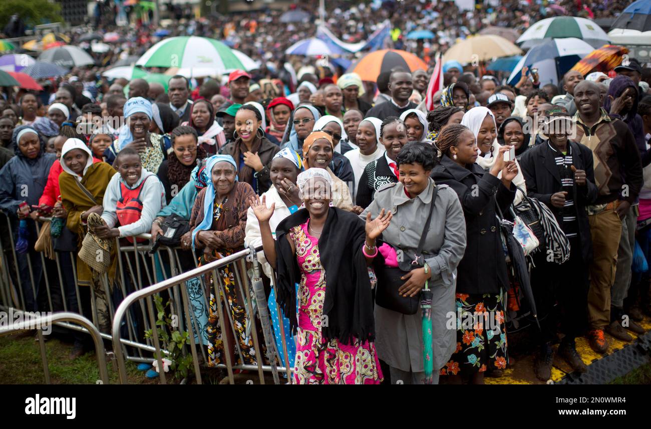 People wait in the rain for the arrival of Pope Francis to celebrate a ...