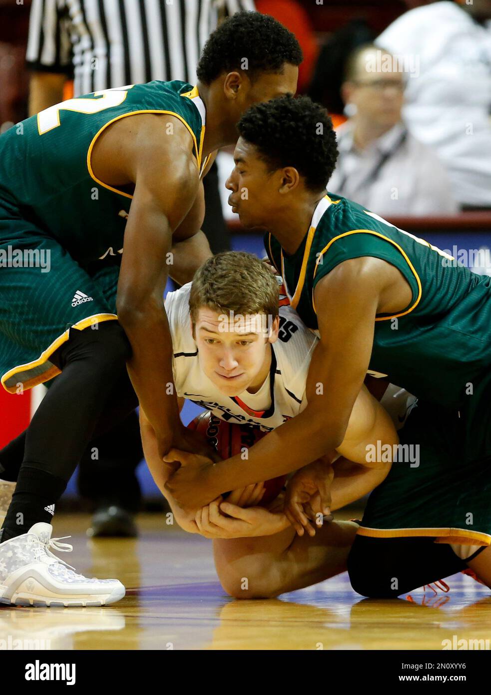 Oklahoma State's Mitchell Solomon, center, gets squished by George ...