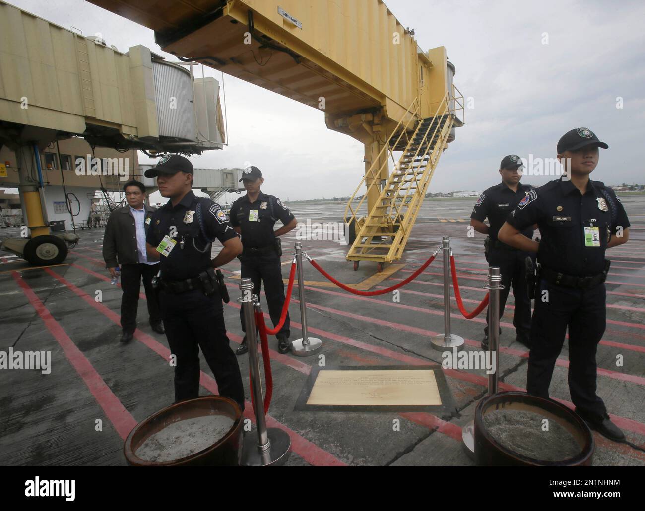 Airport police stand guard at the marker, the exact site where ...