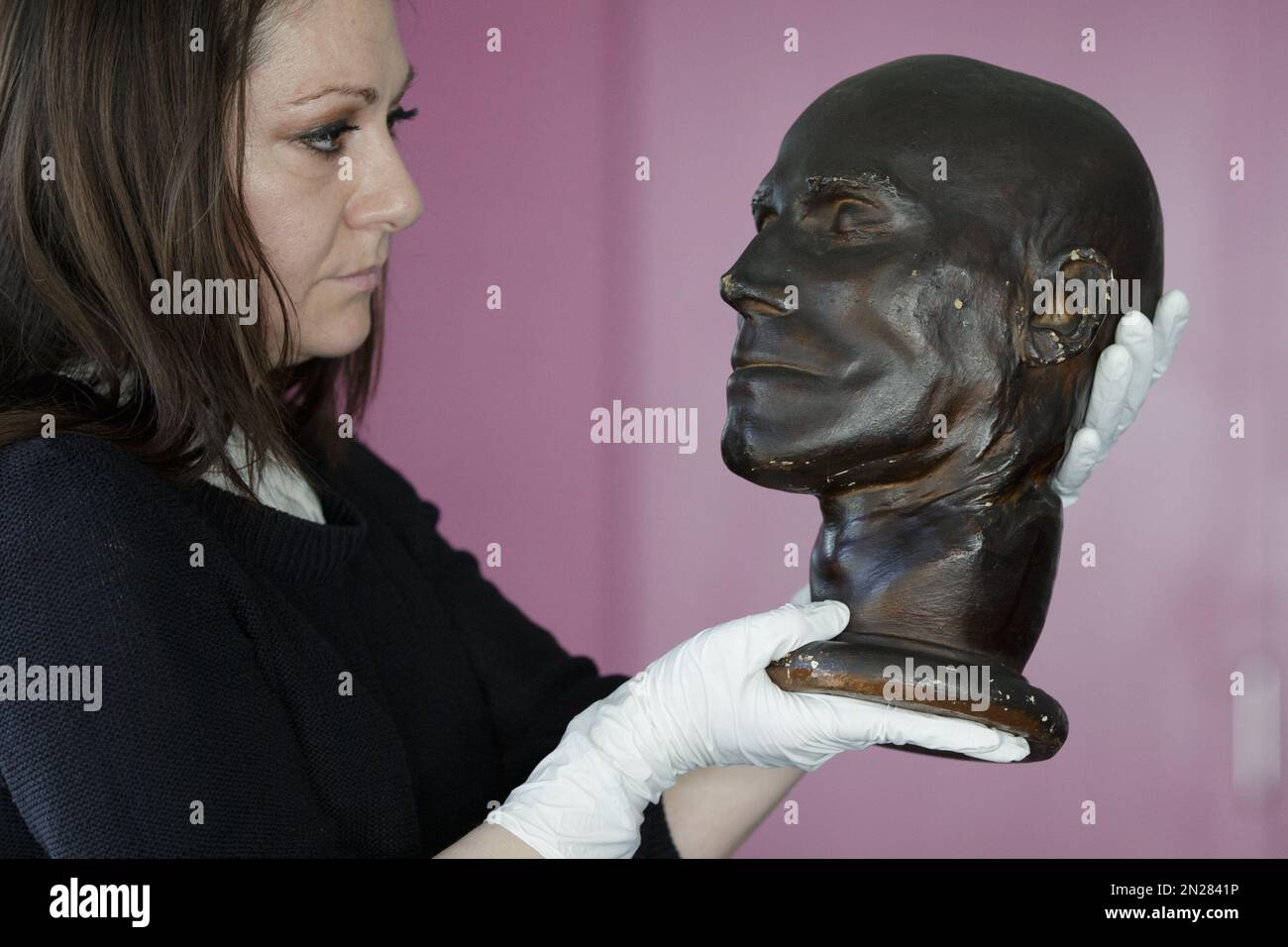 A member of museum staff poses for a picture with the Death Mask of ...