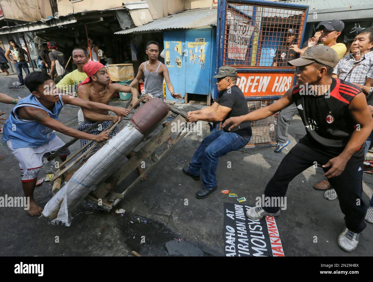 Residents, left, try to prevent a demolition crew from removing their ...