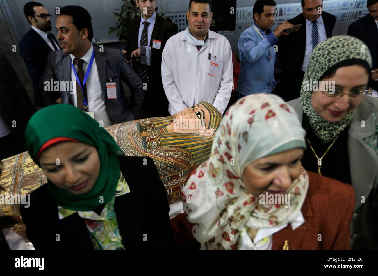 Egyptian antiquities officials pose for a photo with the wooden coffin ...