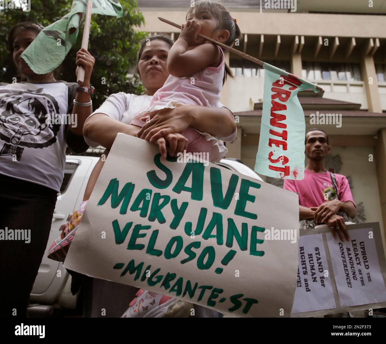 A mother carries her child as they join a rally outside the Indonesian ...