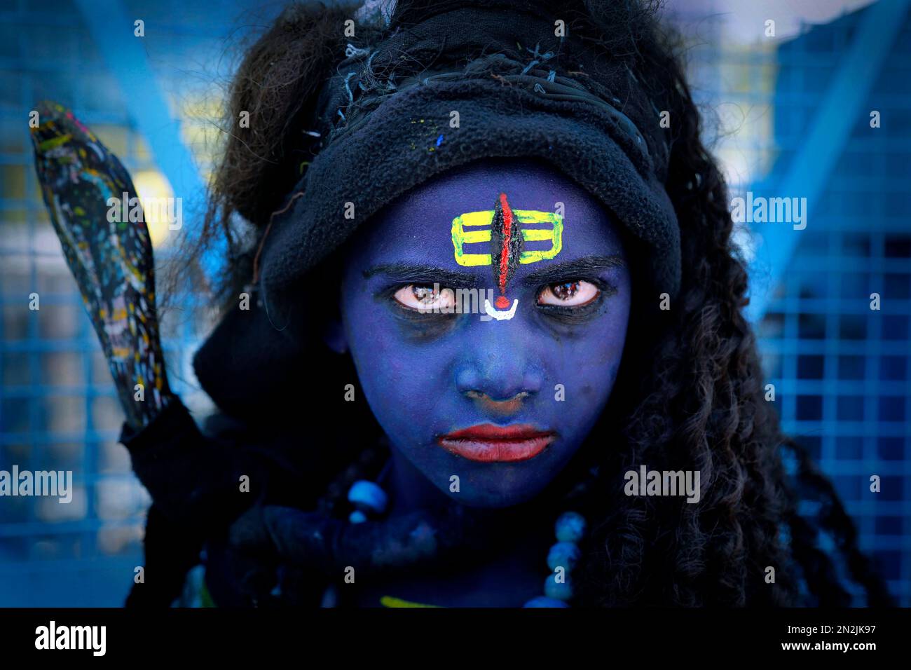 A young Indian boy dressed as Hindu God Shiva waits for alms from ...