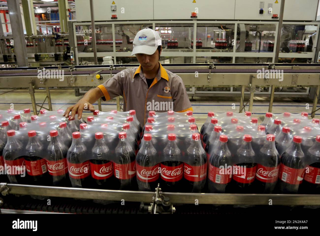 Indonesian workers inspects newly packed Coca-Cola bottles on a new ...