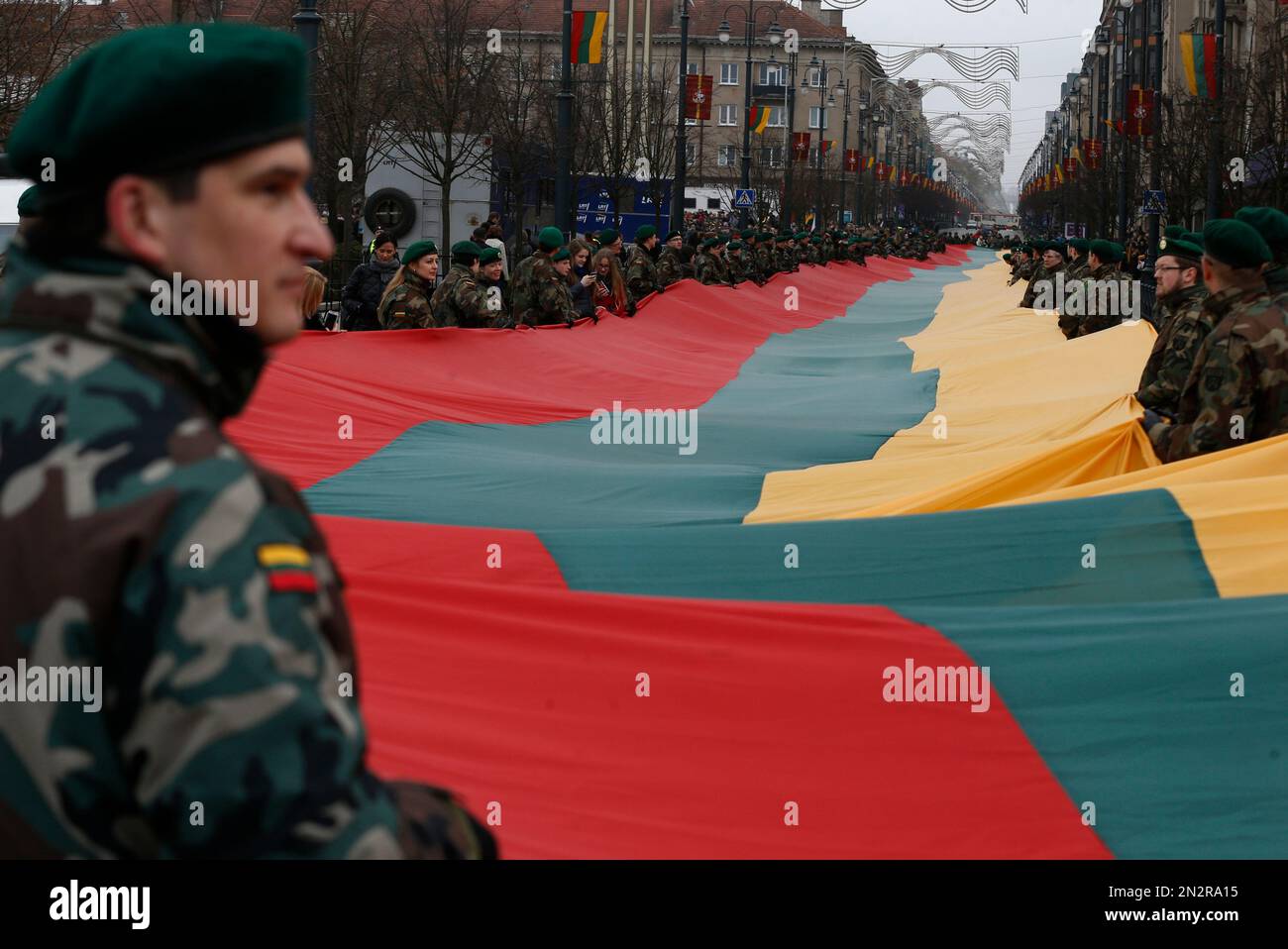 Lithuanian soldiers carry a giant Lithuanian flag during a celebration ...
