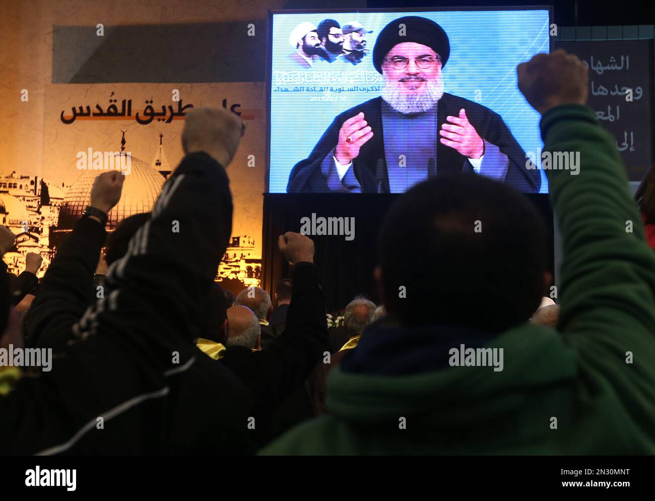 Hezbollah supporters raise their hands and shout slogans as Hezbollah ...