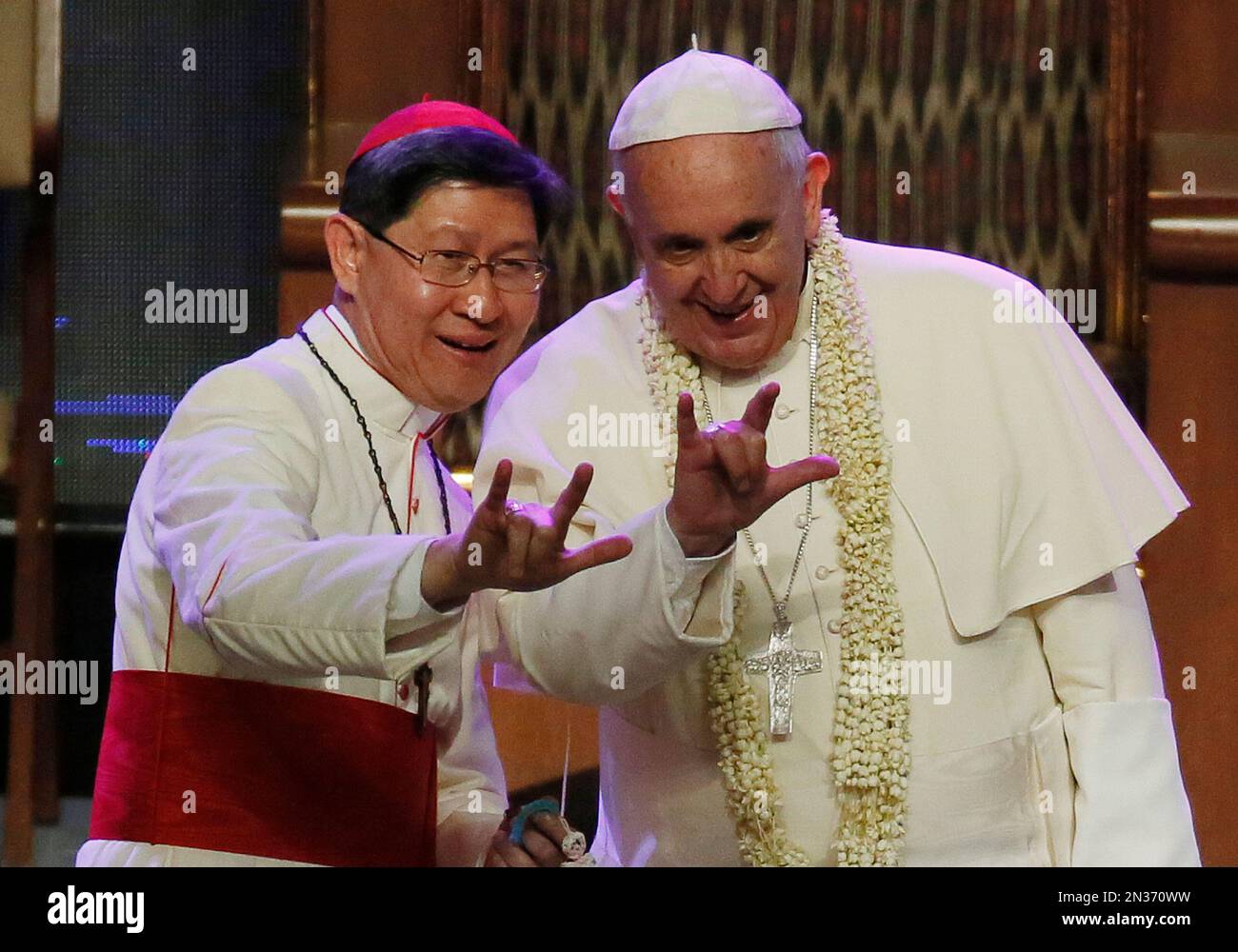Filipino Cardinal Luis Antonio Tagle, left, shows Pope Francis how to ...
