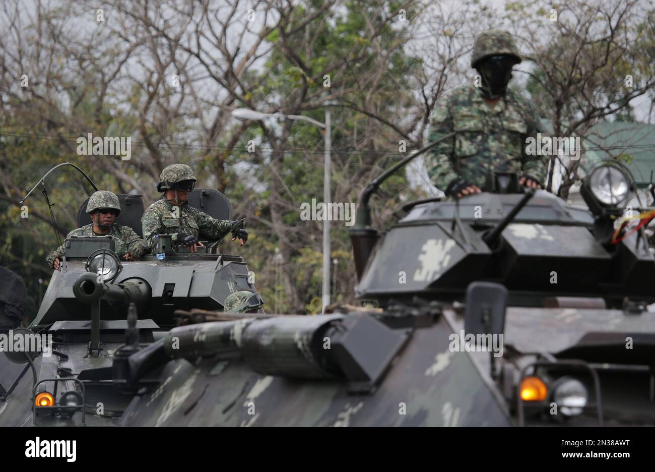 Filipino troopers stand guard on their armored personnel carriers as ...