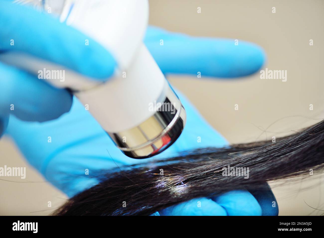 Un gros plan d'un cosmétologue-trichologue diagnostique l'état des cheveux du patient à l'aide d ...