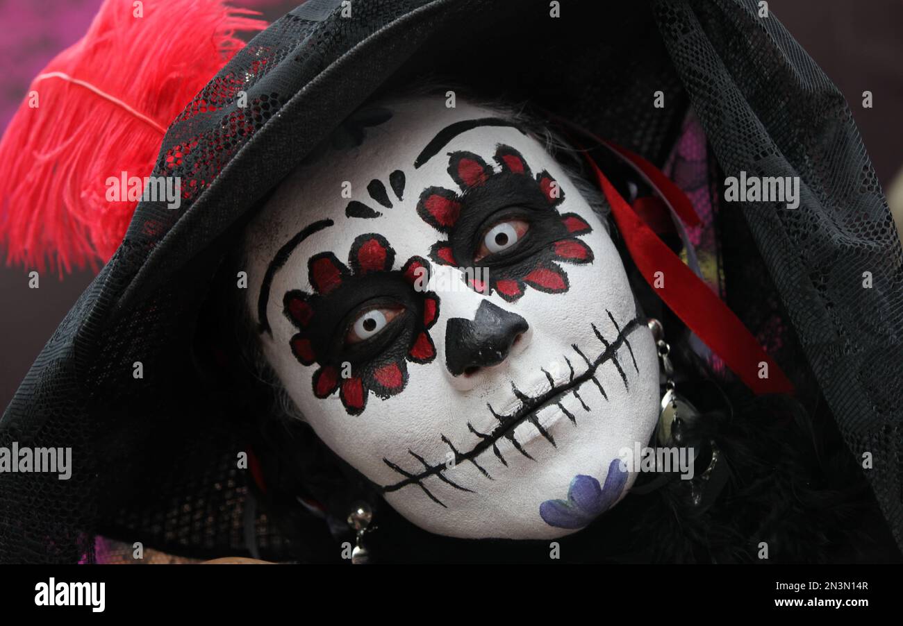 A woman dressed as the iconic Mexican "Catrina" poses for photographers ...