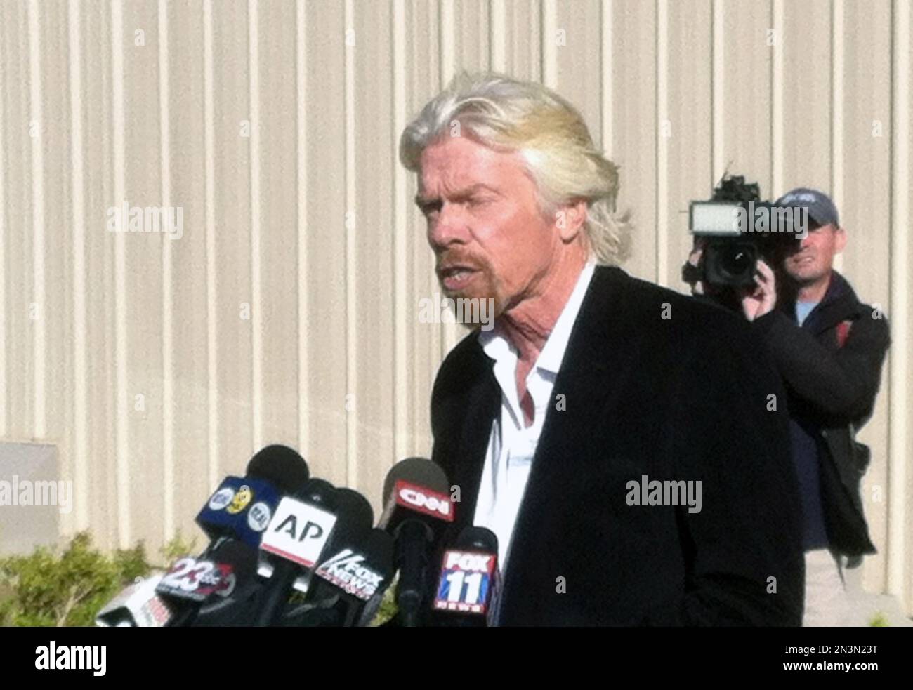 Billionaire Virgin Galactic founder Richard Branson, at podium, salutes ...