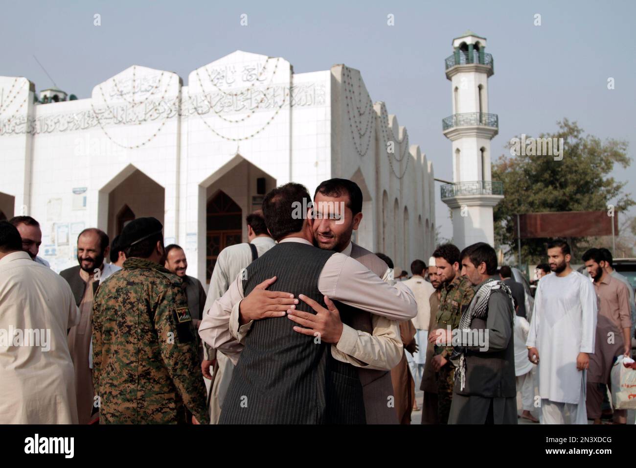 Afghans hug each other after offering Eid al-Adha prayers outside a ...