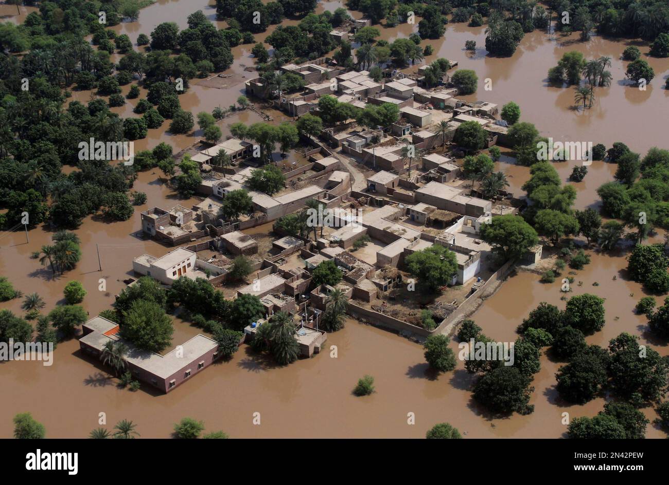 An aerial view shows houses surrounded by flood waters in Multan ...