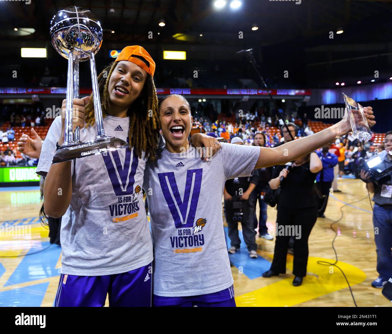 Phoenix Mercury's Brittney Griner, left, holds the WNBA championship trophy as she stands with ...