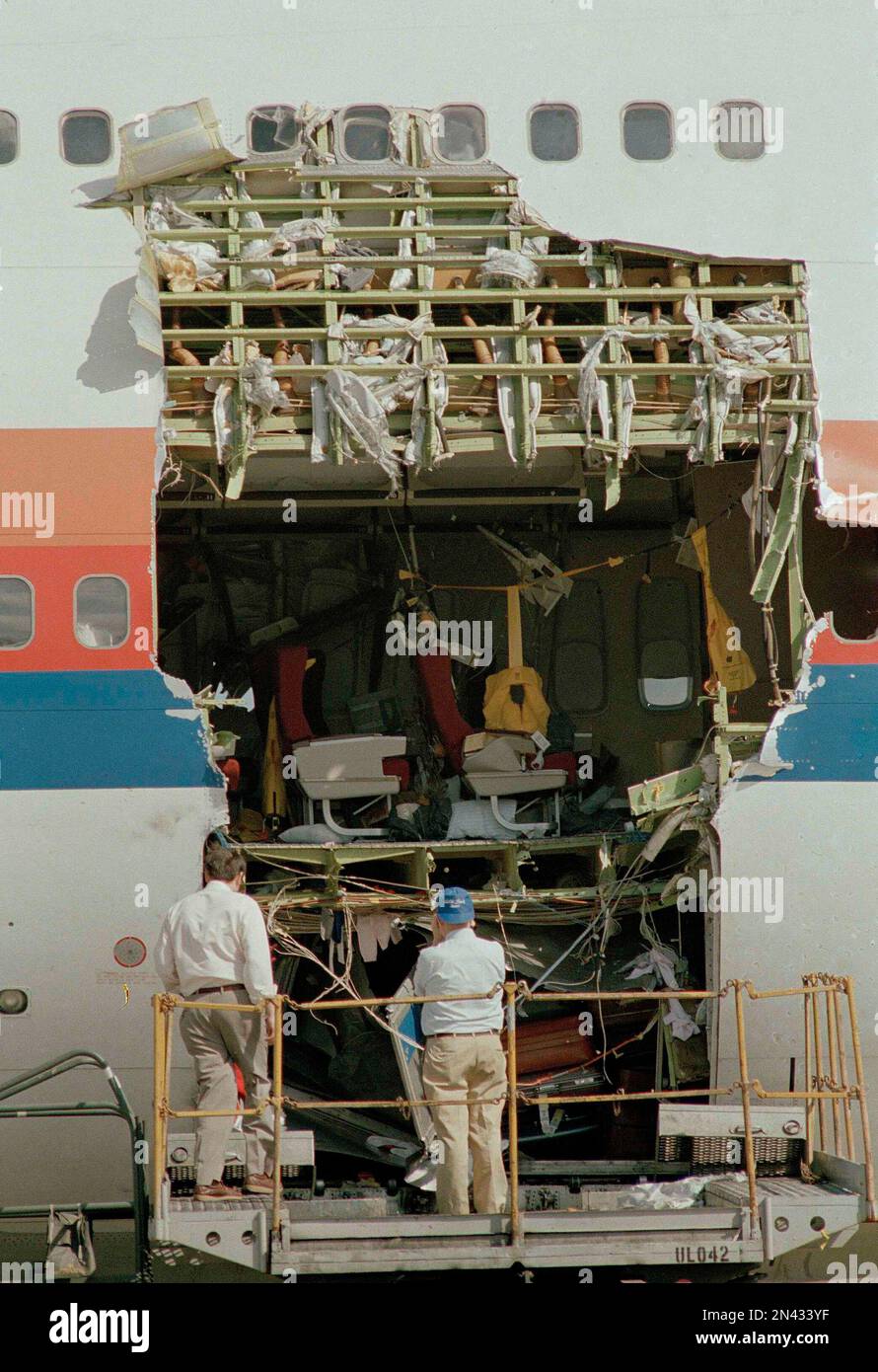 Two inspectors look at the severely damaged United Airlines Flight 811 ...
