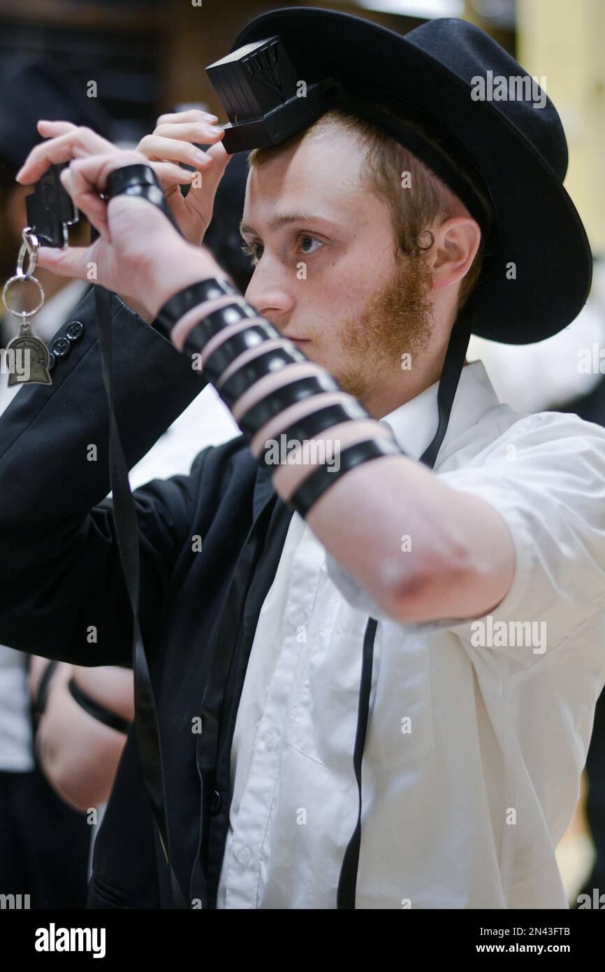 Un jeune juif orthodoxe ajuste sa tefillin de tête pour être sûr qu'il ...