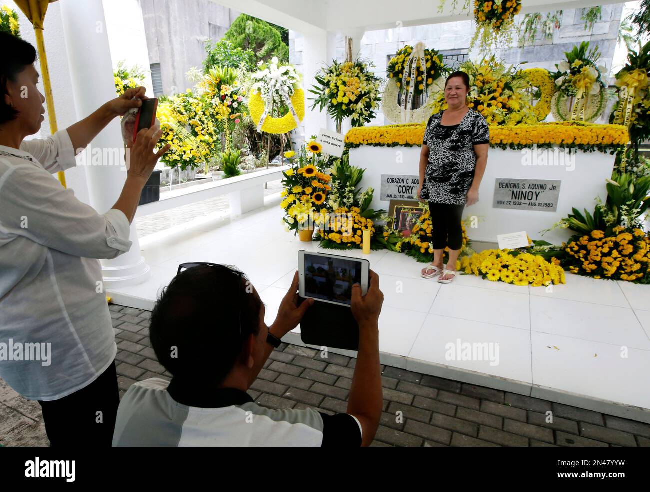 Supporters take souvenir photos at the tomb of assassinated opposition ...