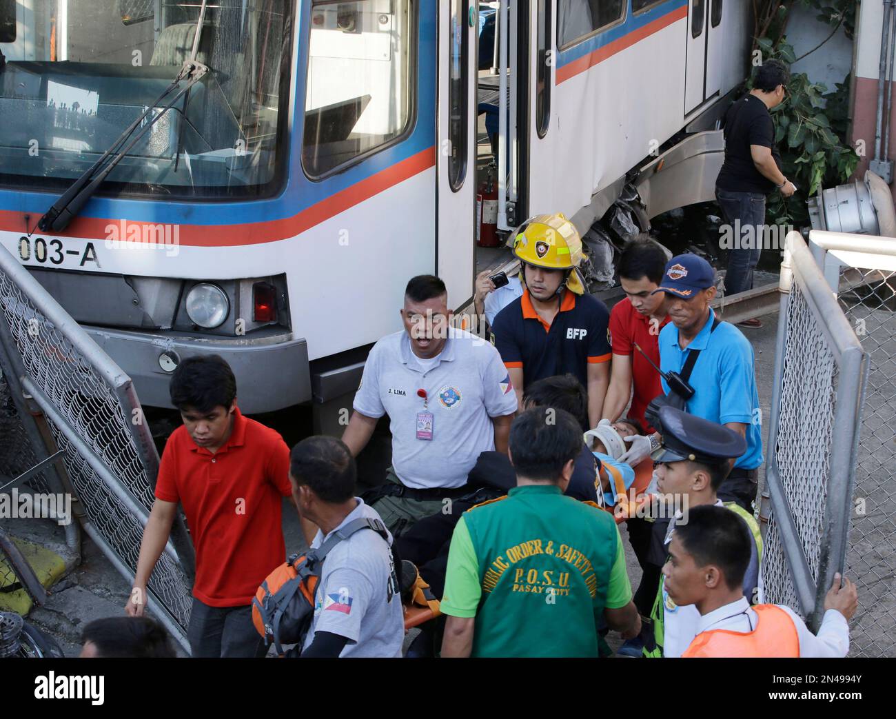 Rescuers rush an injured passenger to a hospital after an elevated commuter train known as Metro ...
