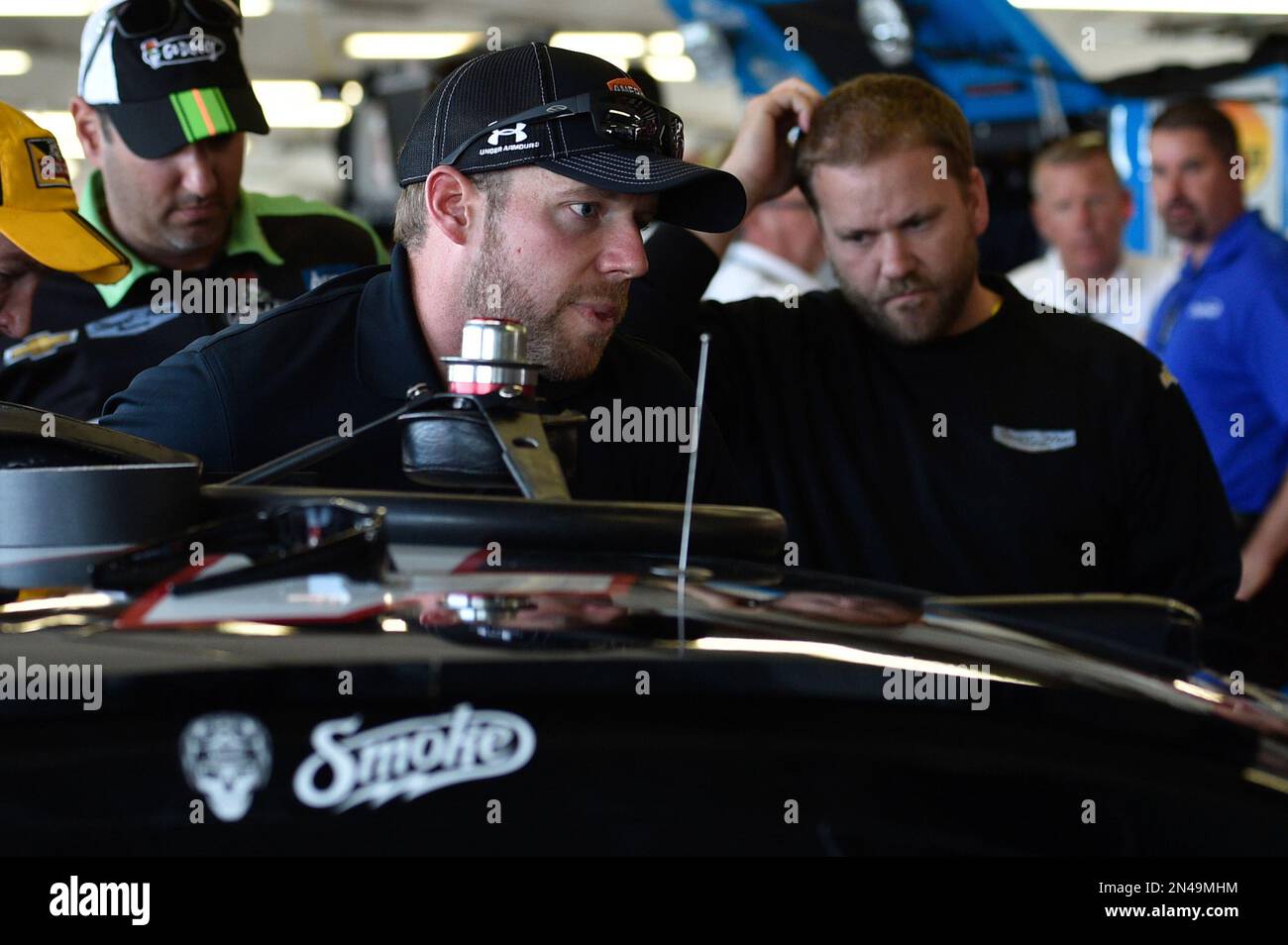 Regan Smith, center, climbs into the race car of Tony Stewart before a ...