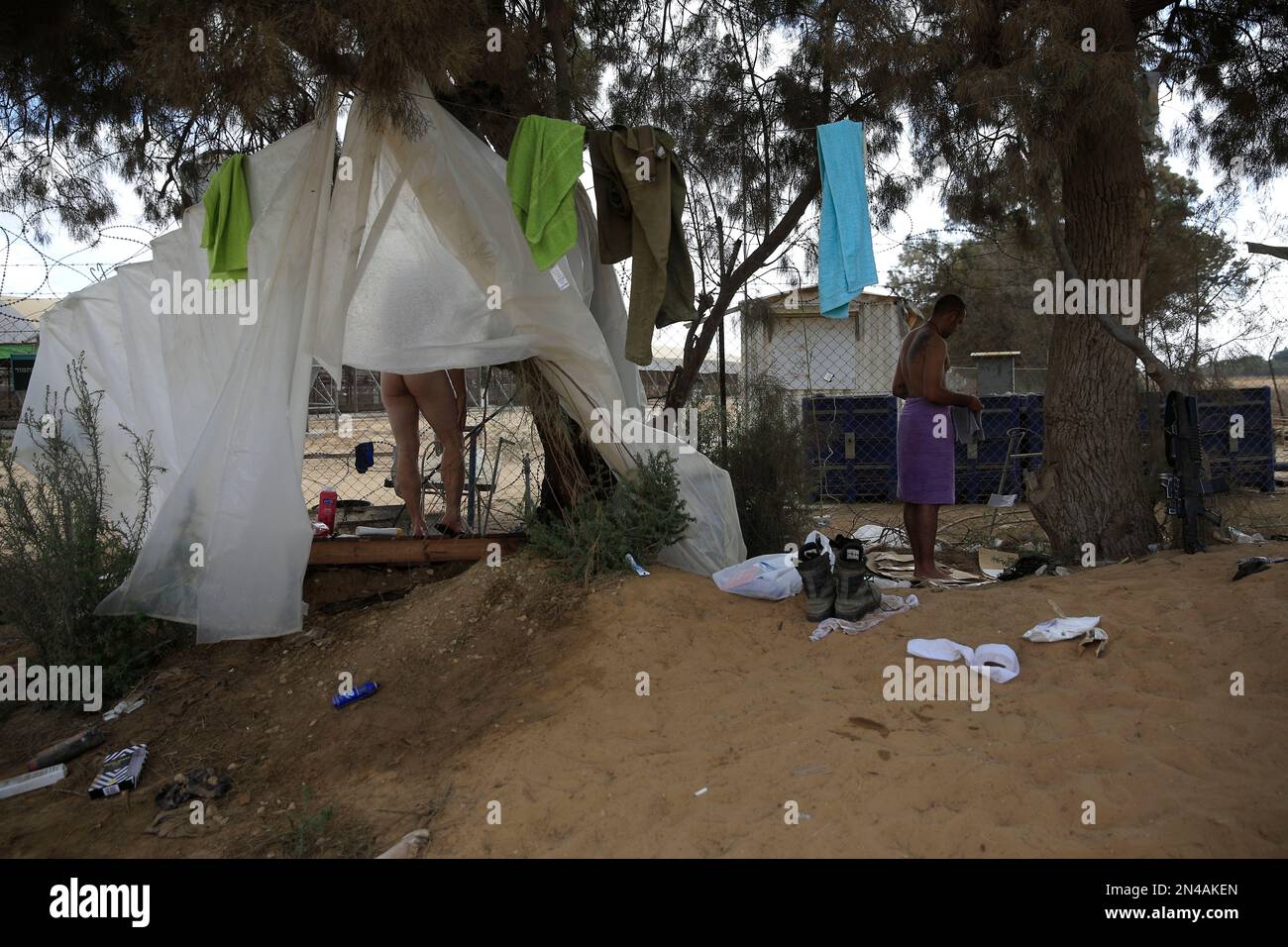 An Israeli soldier takes a shower after returning to Israel from the ...