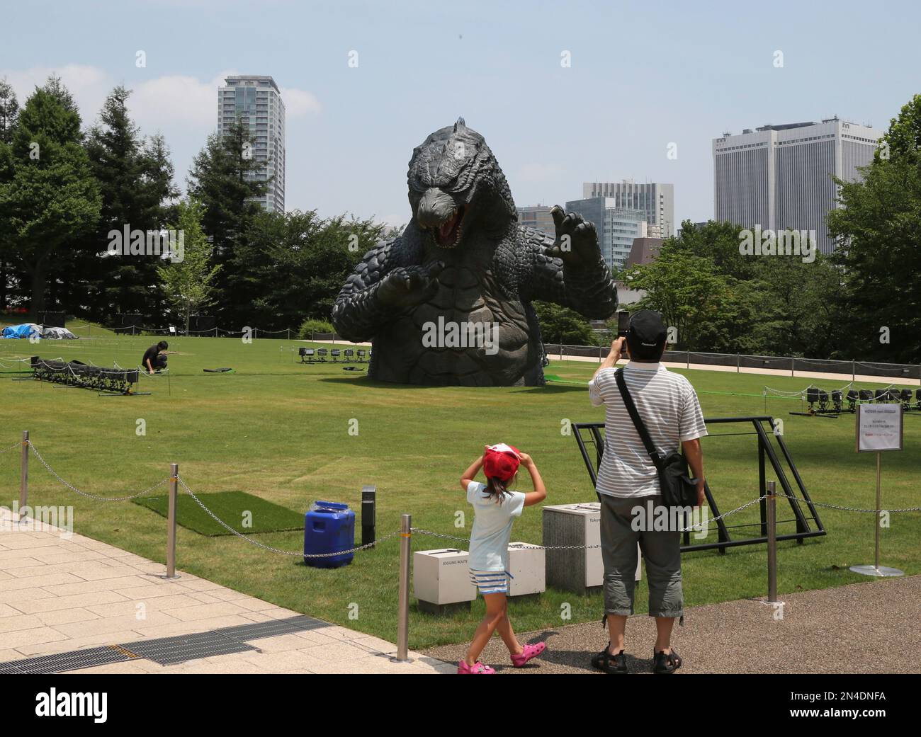 Visitors take a picture in front of a scaled down model of the new ...