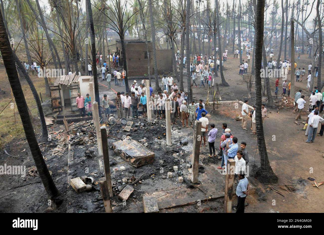 People gather at the site of a pipeline explosion in Nagaram village ...